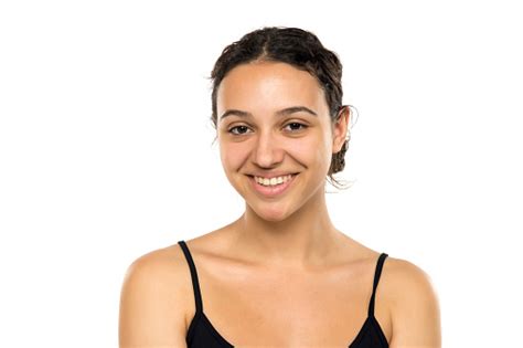 자연스러운 외모에 화장을 하지 않고 카메라를 향해 활짝 웃고 있는 젊은 여성 진심으로 행복한 표정 롤빵에 검은 머리 흰색 배경에 스튜디오 초상화 20 24세에 대한 스톡