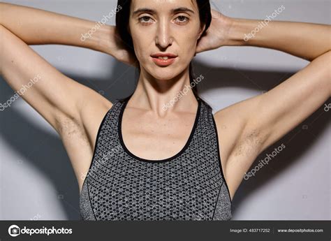 一个女人举起手 露出腋窝下的头发 一个自然的女孩没有刮胡子腋窝 女权主义概念 一个有毛茸茸腋窝的女人身体呈阳性女权运动页 图库照片