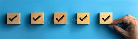 Hand Placing A Check Mark Block On A Blue Background Creating A Sense