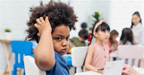 교실에 앉아 스트레스를 받은 아프리카 흑인 소년의 초상화 우울한 학생 어린 아이 어린 소년은 교실에서 미술과 그림을 공부하고 학교에서 카메라를 보는 동안 피곤하고