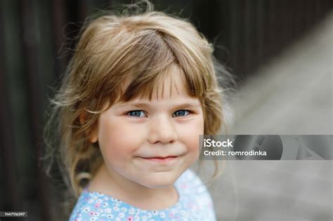 야외에서 행복한 웃는 유아 소녀의 초상화 금발 머리를 가진 어린 아이가 카메라를 보고 미소짓고 있습니다 행복한 건강한 아이는 야외 활동과 놀이를 즐길 수 있습니다 건강한