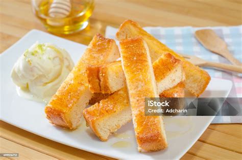 근접 토스트에 허니 버터를 얹은 아이스크림 흰 접시에 배열 하는 막대기로 서브 배경 나무 숟가락 포크 꿀 꿀 디퍼 있다 공간이