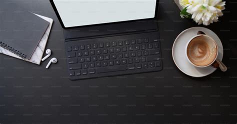 블랙 테이블 작업 공간에 디지털 태블릿과 커피 컵이 있는 세련된 작업 공간의 상위 뷰 사진 Unsplash의 사무실 이미지