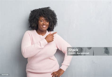 젊은 아프리카계 미국인 플러스 크기 여자 손과 카메라 보고 얼굴에 행복 하 고 자연 식 가진 측까지 손가락으로 가리키는 얼굴의