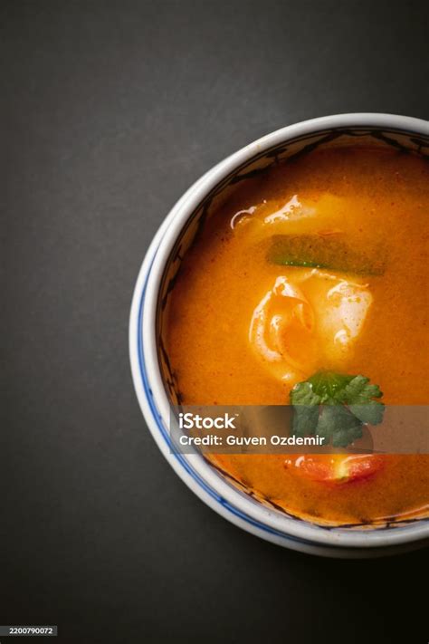 새우 버섯 신선한 허브를 곁들인 태국 똠얌 수프 한 그릇의 평면도 검은 배경의 전통 도자기 그릇에 담겨 제공되는 정통 태국 요리 및 음식 사진 컨셉 0명에 대한 스톡 사진