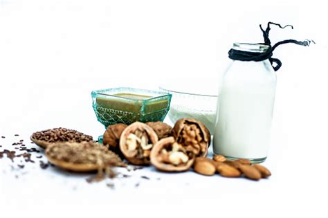 유리 그릇에 아마 씨 또는 알 시 아몬드 요구르트 및 우유와 함께 호두의 얼굴 마스크 또는 얼굴 팩을 흰색으로 절연 된 전체 원료 성분으로 닫습니다 기름기 있는에 대한 스톡