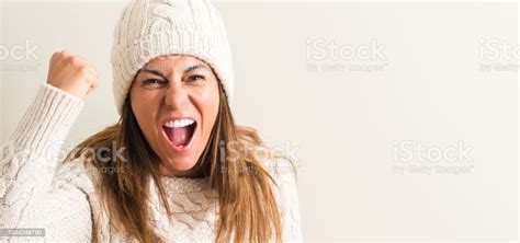 모직 겨울 모자를 착용 해 중간 나이 여자 화가 좌절 분노 미친 제기 손으로 소리를 외치는 분노 개념 갈색 머리에 대한 스톡
