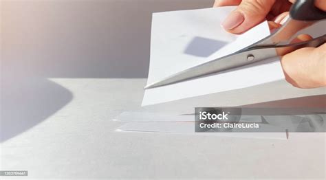 Tangan Seorang Wanita Memotong Selembar Kertas Putih Dengan Gunting Dan