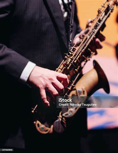 색소폰 연주자 음악가 색소폰 색소폰 연주자 보컬리스트와 뮤지컬 밴드와 함께 재즈 오케스트라 쇼 중 무대에서 음악을 연주하는 장면 조명 뮤지컬 클럽 홀에서 콘서트 전경