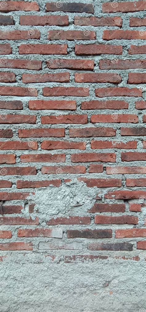 A Captivating Photo Showcasing A Red Brick Wall With Visible Brick Pieces And Subtle Patches Of