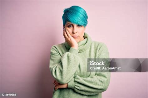 피곤 하고 교차 된 팔에 우울증 문제로 지루해 보이는 생각 캐주얼 터틀넥 스웨터를 입고 파란색 패션 머리를 가진 젊은 아름다운