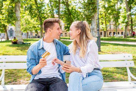 공공 공원에서 휴대 전화를 사용하고 신용 카드를 들고 젊은 부부 20 29세에 대한 스톡 사진 및 기타 이미지 20 29세 2명 공원 Istock