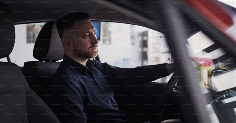 블랙 셔츠에 그의 호화로운 빨간 차에 앉아 있는 젊은 수염 난 사업가의 측면 모습 사진 Unsplash의 우크라이나 이미지