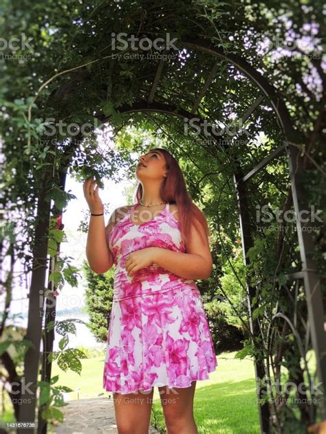분홍색과 흰색 드레스를 입은 젊은 십대 코카시온 여성이 포도 나무로 덮인 정원 Arbor 아래 야외에 서 있습니다 14 15 살에 대한 스톡 사진 및 기타 이미지 Istock