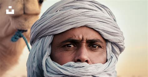 배경에 낙타가 있는 터번을 쓴 남자 사진 Unsplash의 무료 스카프 이미지