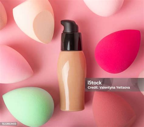 분홍색 배경에 기초가 있는 뷰티 블렌더 메이크업 화장품을위한 밝은 스폰지 메이크업 제품 아름다움 개념입니다 텍스트를 위한 위치입니다 복사를 위한 공간입니다 플랫 레이 0명에