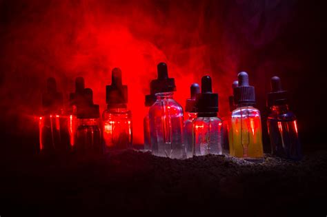 Vape 개념입니다 구름과 어두운 배경에 Vape 액체 병 연기 빛 효과입니다 배경 또는 Vape 광고 Vape 배경으로 유용 합니다 0명에 대한 스톡 사진 및 기타 이미지