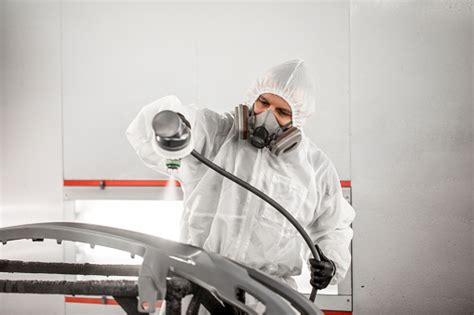 자동차 차체가 게에서 스프레이 건을 사용 하 여 자동차 파트에 페인트를 적용 한 회화 기술자 스프레이 도장에 대한 스톡 사진 및