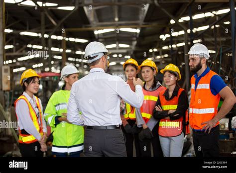 Architect Civil Engineer And Worker Looking At Plans And Blueprints