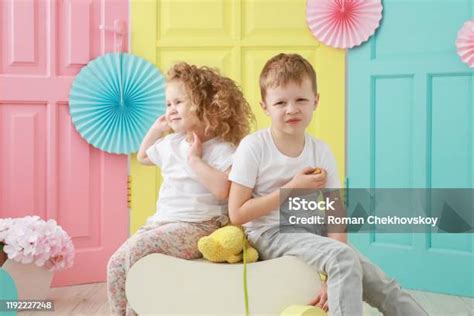 노란색 분홍색과 파란색 배경에 흰색 티셔츠에 꽤 작은 금발 곱슬 소녀와 화가 소년 초상화 아이 성 관계 개념입니다 가족에 대한 스톡 사진 및 기타 이미지 Istock