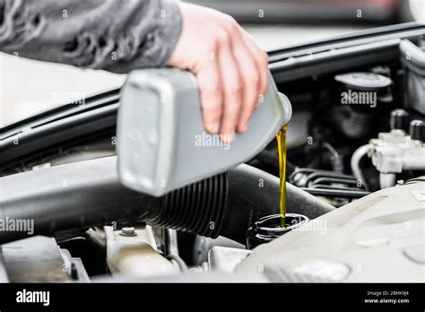 Woman Putting Oil Into The Engine Of Her Car Stock Photo Alamy
