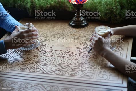 카페에서 함께 즐기는 여자 친구 젊은 여자는 카페에서 회의 커피에 대 한 카페에서 두 여성 회의 파란 드레스 드레스의 꽃 조각된 테이블에는 Lampdrink 커피 컵 갈색