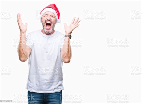 중 년 노인의 수석 남자 이상 크리스마스 모자를 쓰고 절연 배경 화 축 하 하 고 무기와 성공을 위해 미친 제기 흥분 비명 눈을