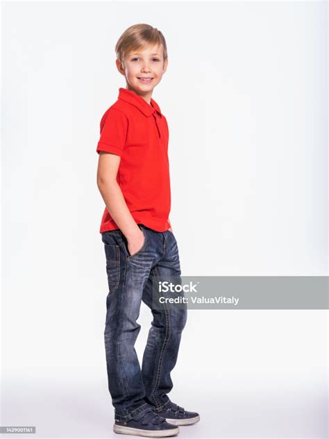 패션 모델로 스튜디오에서 포즈를 취하는 어린 예쁜 소년 8 세 아이의 사진 고립 된 행복한 소년의 전체 초상화 빨간 티셔츠와