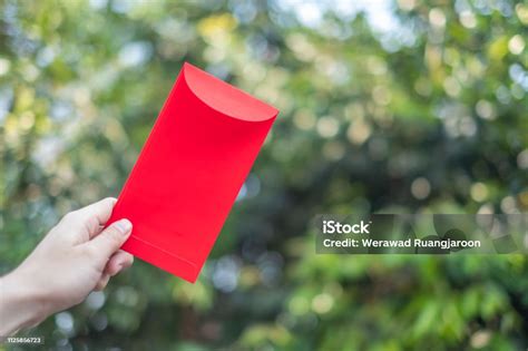 행복 한 중국 새 해 손을 잡고 빨간 봉투 또는 나무에서 녹색 Bokeh 배경에 고립 된 Angpao 라는 2월에 대한 스톡 사진 및 기타 이미지 Istock