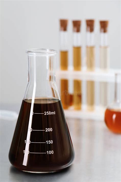 conical flask with brown liquid on table stock image image of light