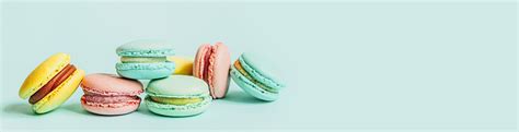달콤한 아몬드 화려한 핑크 블루 옐로우 그린 마카롱 또는 마카롱 디저트 케이크는 트렌디 한 블루 파스텔 배경에 고립 프렌치 스위트 쿠키 최소한의 식품 베이커리 개념 플랫