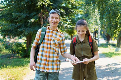 학교 학생들 십대 소년과 소녀가 거리를 걷고 재미있게 이야기하고 책을 읽고 도시 공원에서 밝은 여름날 길과 나뭇잎을 가지고
