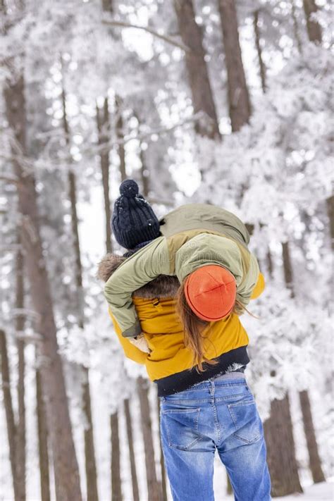 Copains Portant Une Petite Amie Sur Son Dos Dans La Neige Image Stock