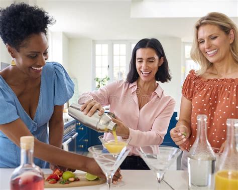 Three Mature Female Friends At Home Having Fun Mixing Cocktails