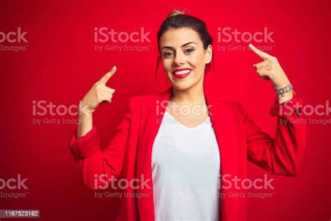 젊은 아름다운 비즈니스 여자 서 서 빨간 고립 된 배경 미소 가리키는 머리와 함께 두 손으로 손가락 좋은 아이디어 또는 생각 좋은 기억 가리키기에 대한 스톡 사진 및 기타