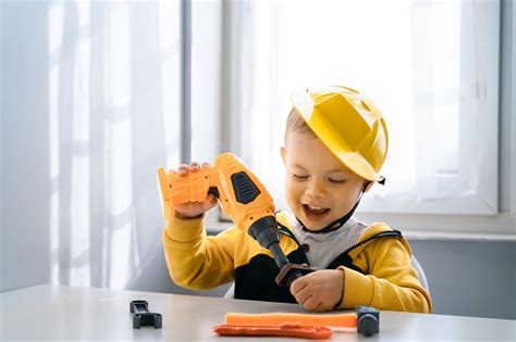 아이들은 집에서 작업 도구를 가지고 놀고 엔지니어가되는 꿈을 꾼다 어린 소년 건축업자 교육 상상력 목적성 개념 아이와 훈련 2 3 살에 대한 스톡 사진 및 기타 이미지