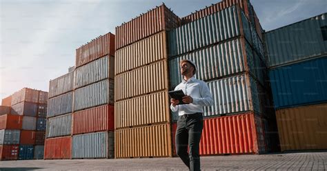 프로세스 제어 디지털 태블릿을 들고 있습니다 남성 작업자가 컨테이너가 있는 위치에 있습니다 사진 Unsplash의 강철 이미지