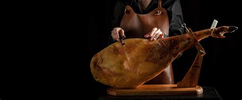 Professional Cutter Carving Slices From A Whole Bonein Serrano Ham