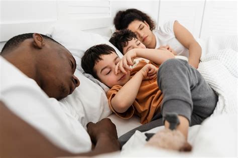 Ni Os Lindos Tratando De Dormir En La Cama De Sus Padres Foto Gratis