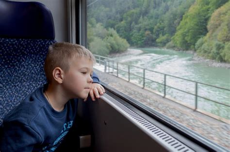 기차 창 밖을 신중하게 바라보는 어린 소년 프리미엄 사진