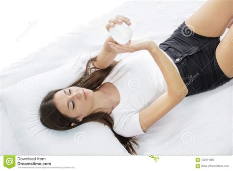 Beautiful Girl Applying Body Lotion To Her Arm While Lying On Be Stock