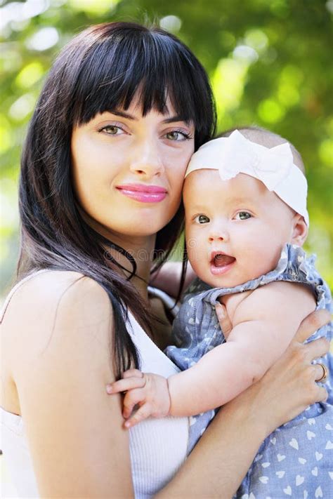 Мать держит младенца на руках Стоковое Изображение изображение насчитывающей смех детство