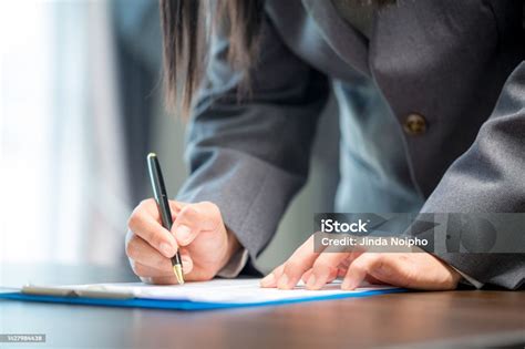 직장 근접 촬영 사람 전문 사업가가 책상에 앉아 펜 서명 또는 서명 계약서를 소지합니다 직장 사무실에서 서류 양식 법인에 계약서를 작성하는 직원 여성 개념에 대한 스톡 사진