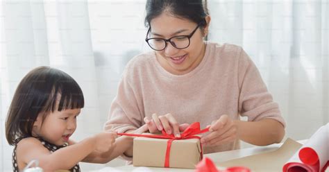 젊은 엄마와 딸이 하얀 방에서 생일 크리스마스 새해 선물 상자를 포장하고 있다 집에서 행복한 아시아 가족 공간을 복사합니다 사진 Unsplash의 기쁨 이미지