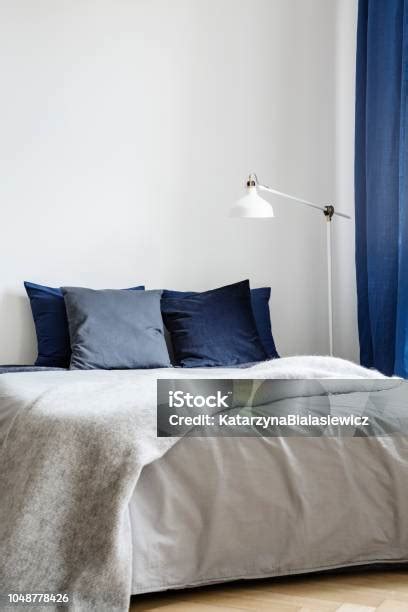 Bekväma Och Minimalistisk Dubbelsäng Med Mörka Kuddar Och Ett Täcke Av En Vit Tom Vägg I En