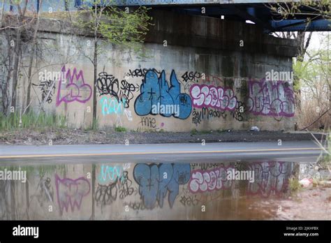 A Beautiful View Of The Reflection Of Graffiti Under Overpass Stock