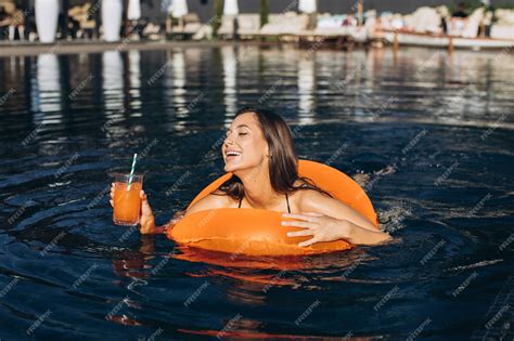 Sexy Woman In Bikini Enjoying Summer Sun And Tanning During Holidays In Pool With Cocktail