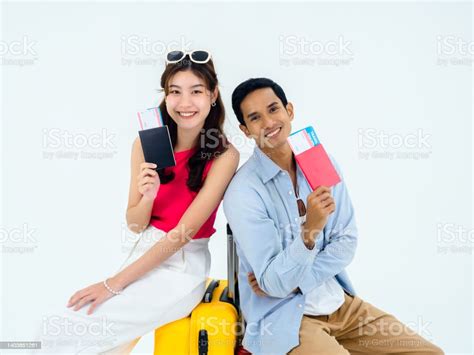 여행 준비 행복한 휴가 여름 방학 개념 여권과 항공권을 들고 웃는 아시아 커플 카메라를 보며 젊은 여성과 남성은 흰색 배경에