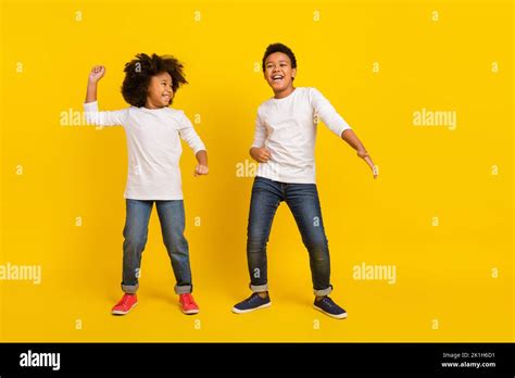 Full Size Photo Of Excited Funky Pupils Enjoy Dancing Disco Isolated On Yellow Color Background