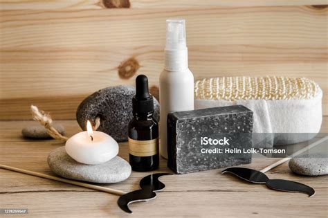 다양한 남자 스파 제품 것들의 위의 보기 세트 평평한 바다 돌이있는 천연 목재 디스크 배경 회색 점토 비누 바 수염 기름 보습 크림 촛불 굽기 재미있는 콧수염 모양 의 인형